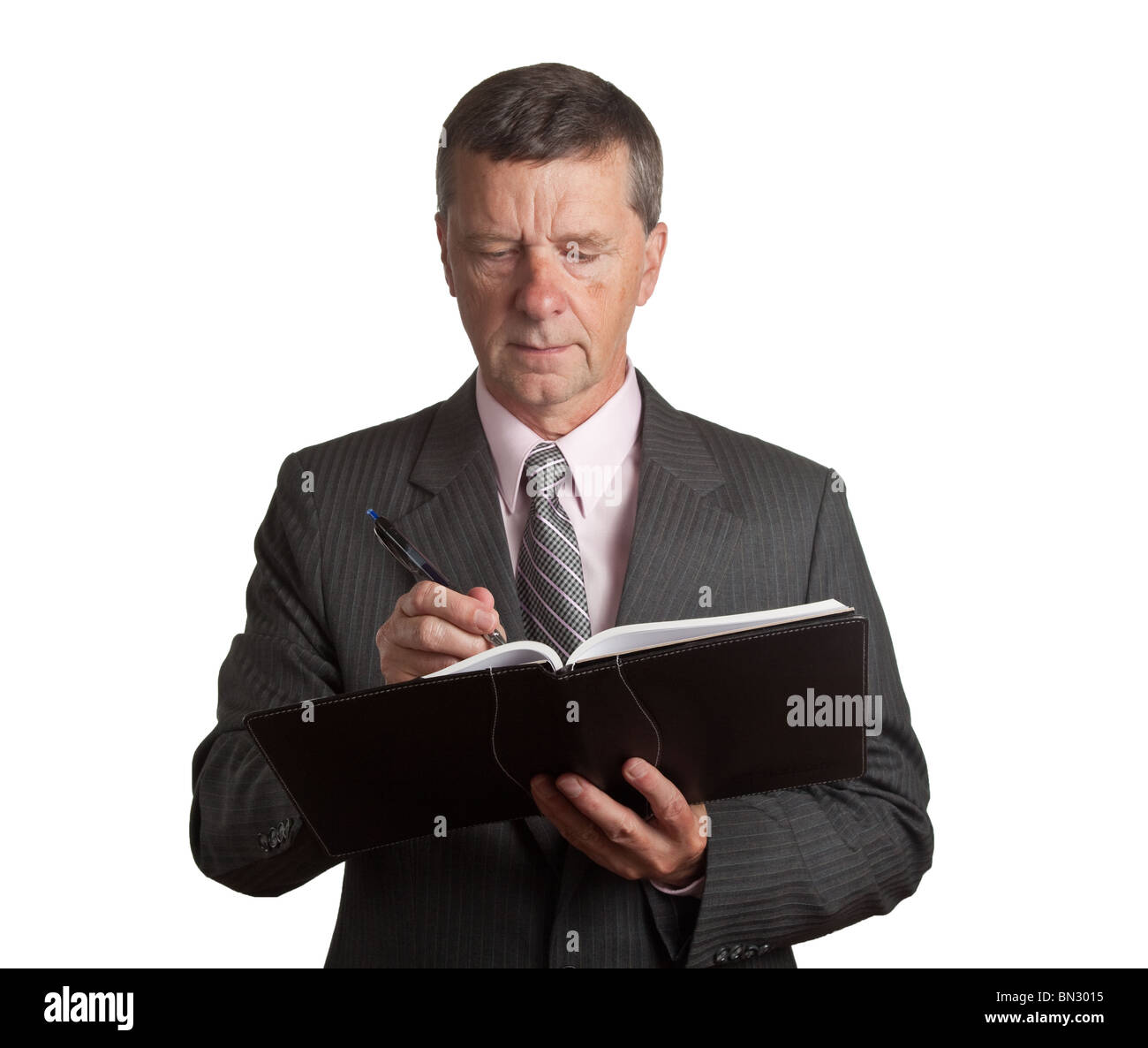 Senior businessman making a note in a black notebook Stock Photo - Alamy