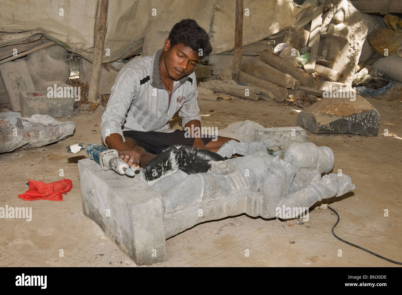 India Tamil Nadu Mamallapuram an Indian craftsman carving a stone ...
