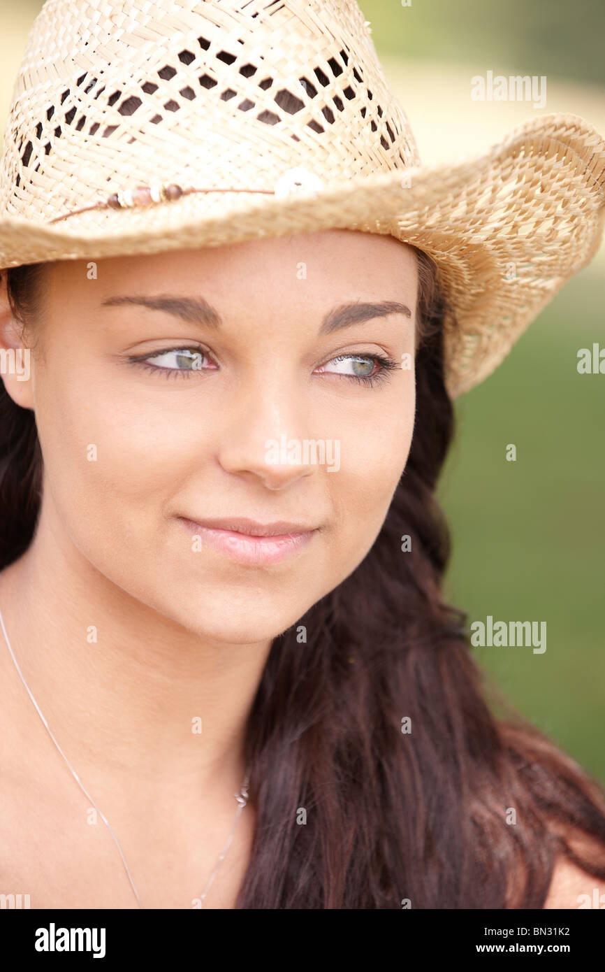 Portrait Of Smiling Attractive Young Woman Wearing Straw Hat Stock