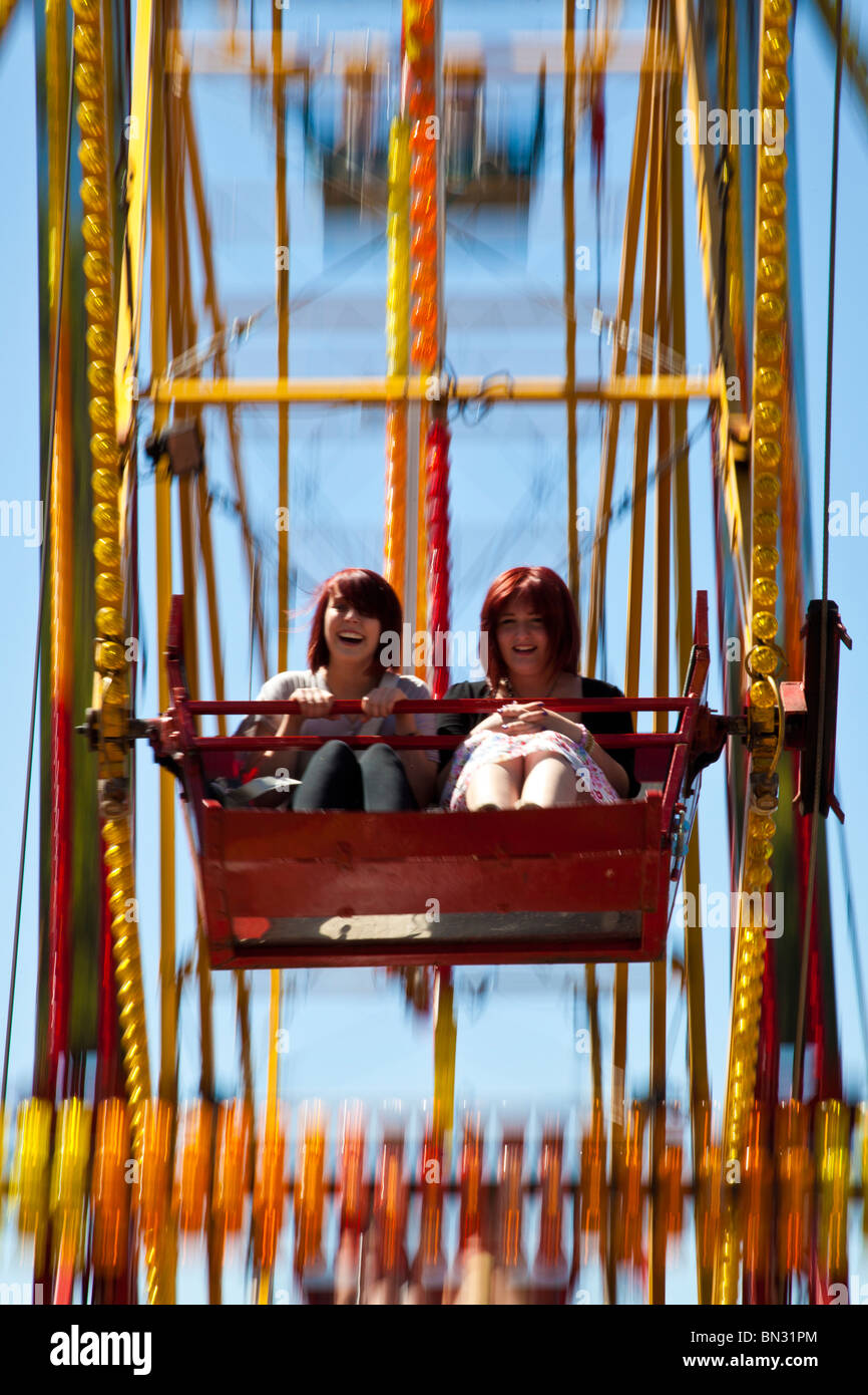 Two happy teenage girls riding on big wheel fairground ride Stock Photo ...