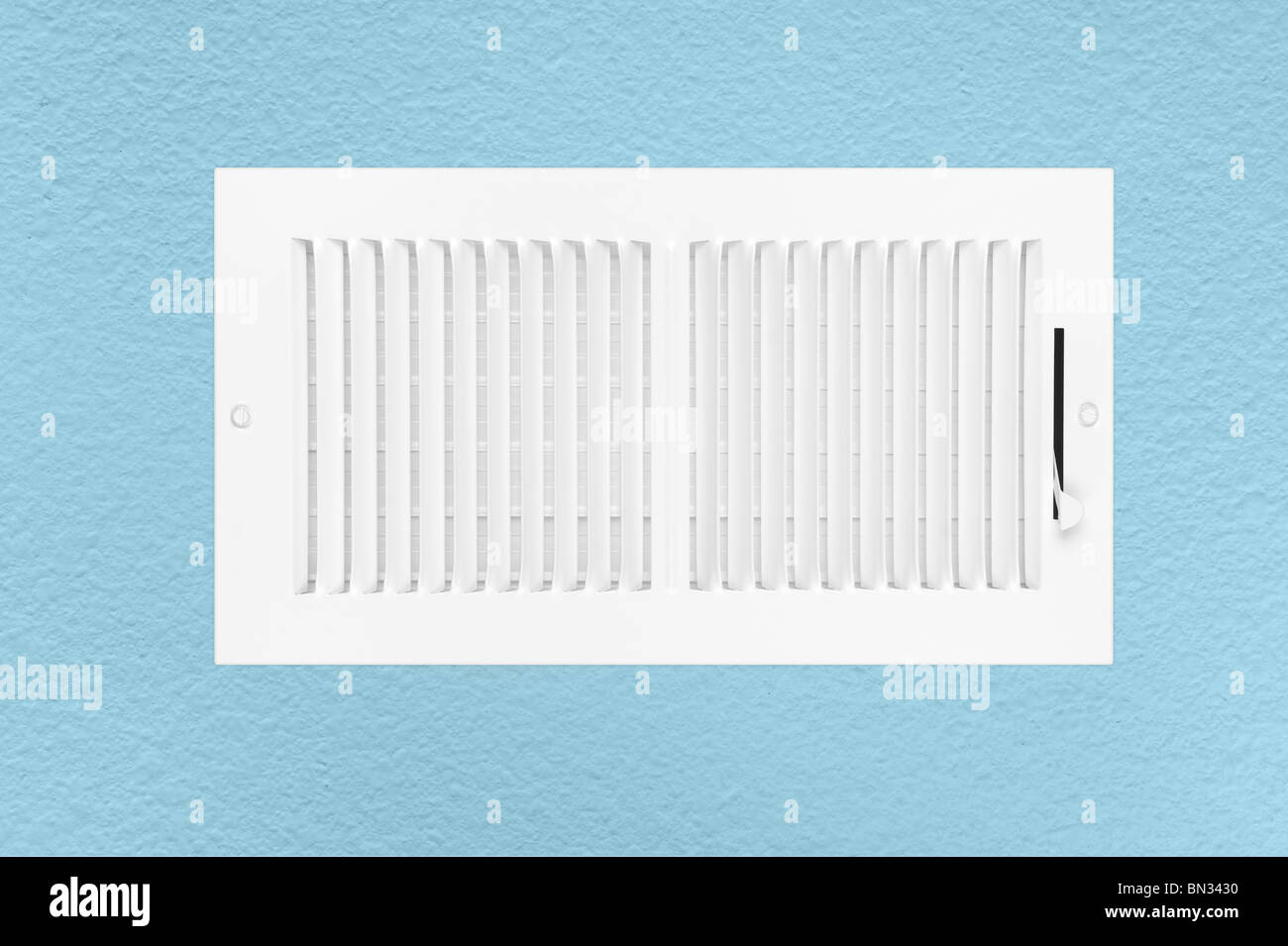 A new heating and air conditioning wall vent on a blue textured wall ...