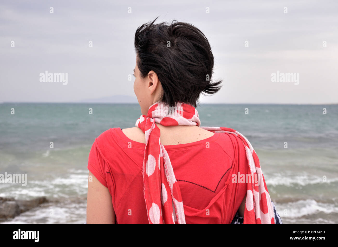 Woman looking at ocean, rear view Stock Photo - Alamy
