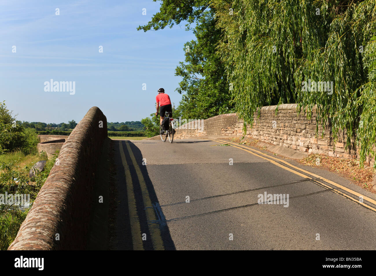 A cyclist crossing the narrow Harrold Bridge towards the village of ...