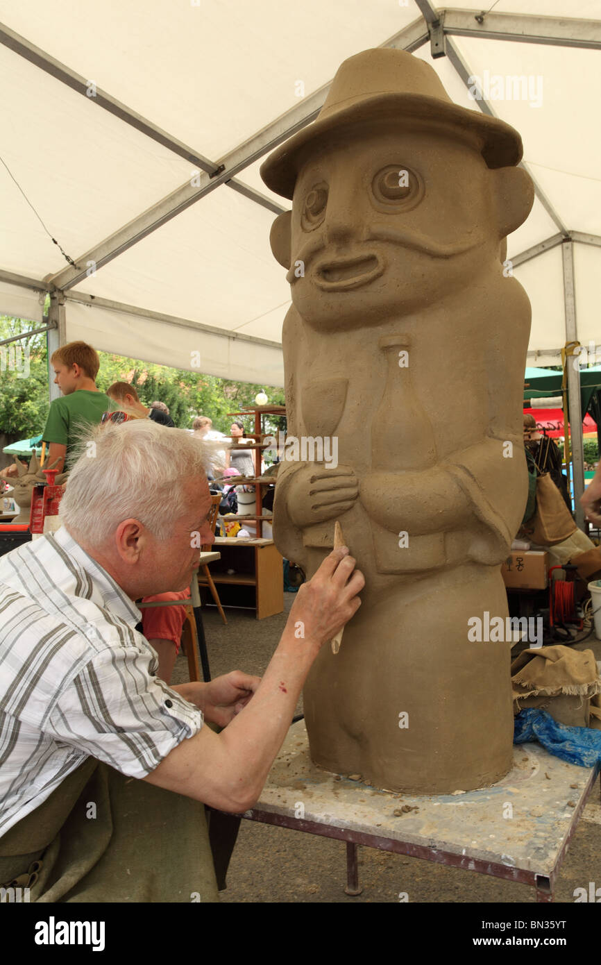 Ceramist at work, creating funny human character from clay, at the ...