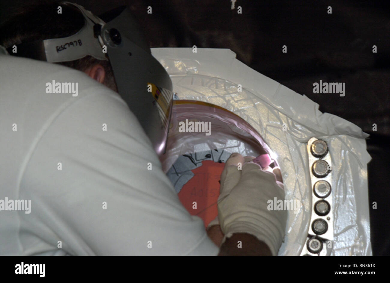 United Space Alliance technician Jerry Goudy performs arc welding on ...
