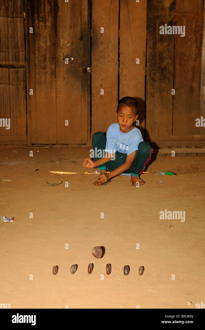 Young Black Lahu boy playing with stones on the floor, hill tribe of ...