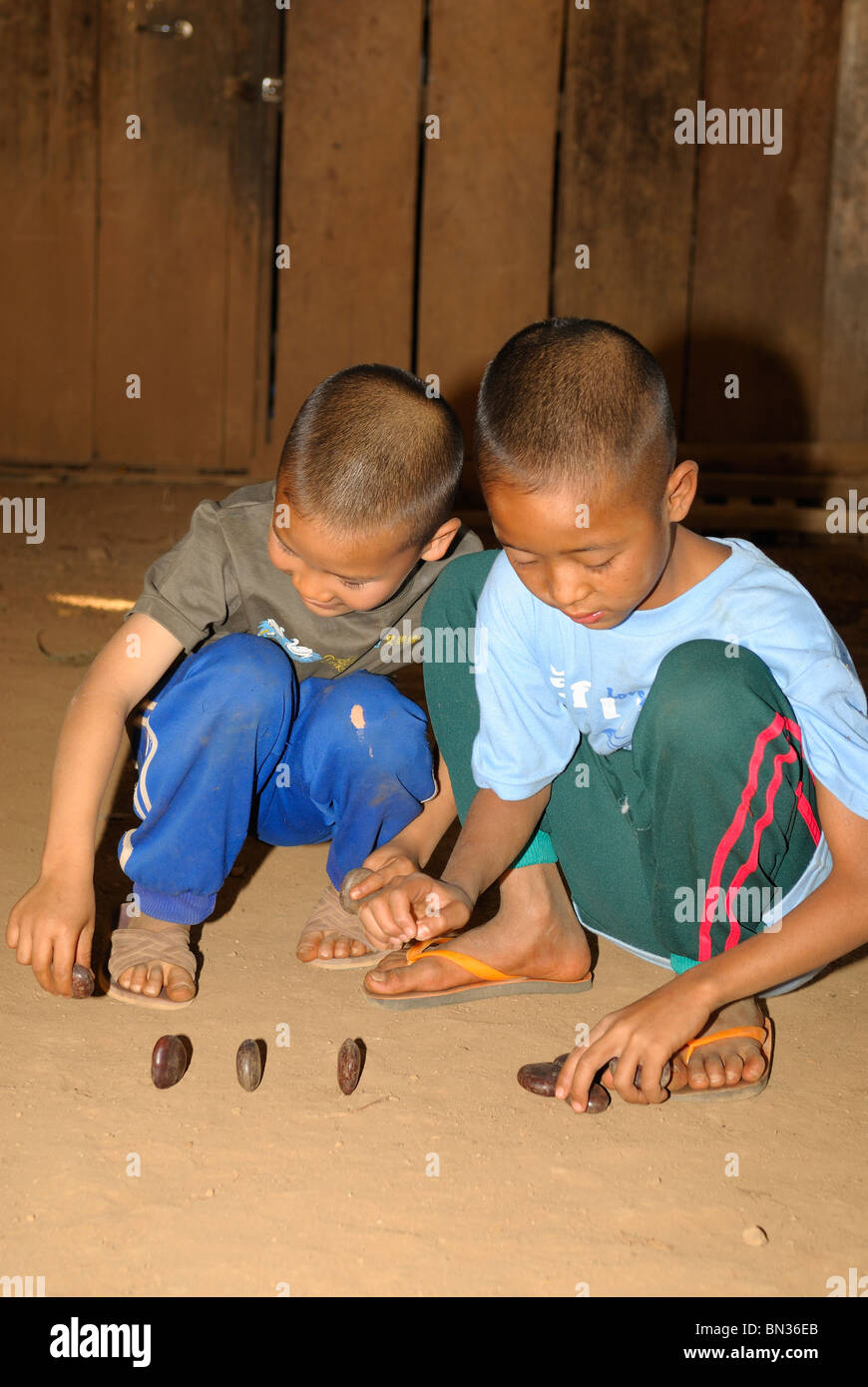 Young Black Lahu boys playing with stones on the floor, hill tribe of ...