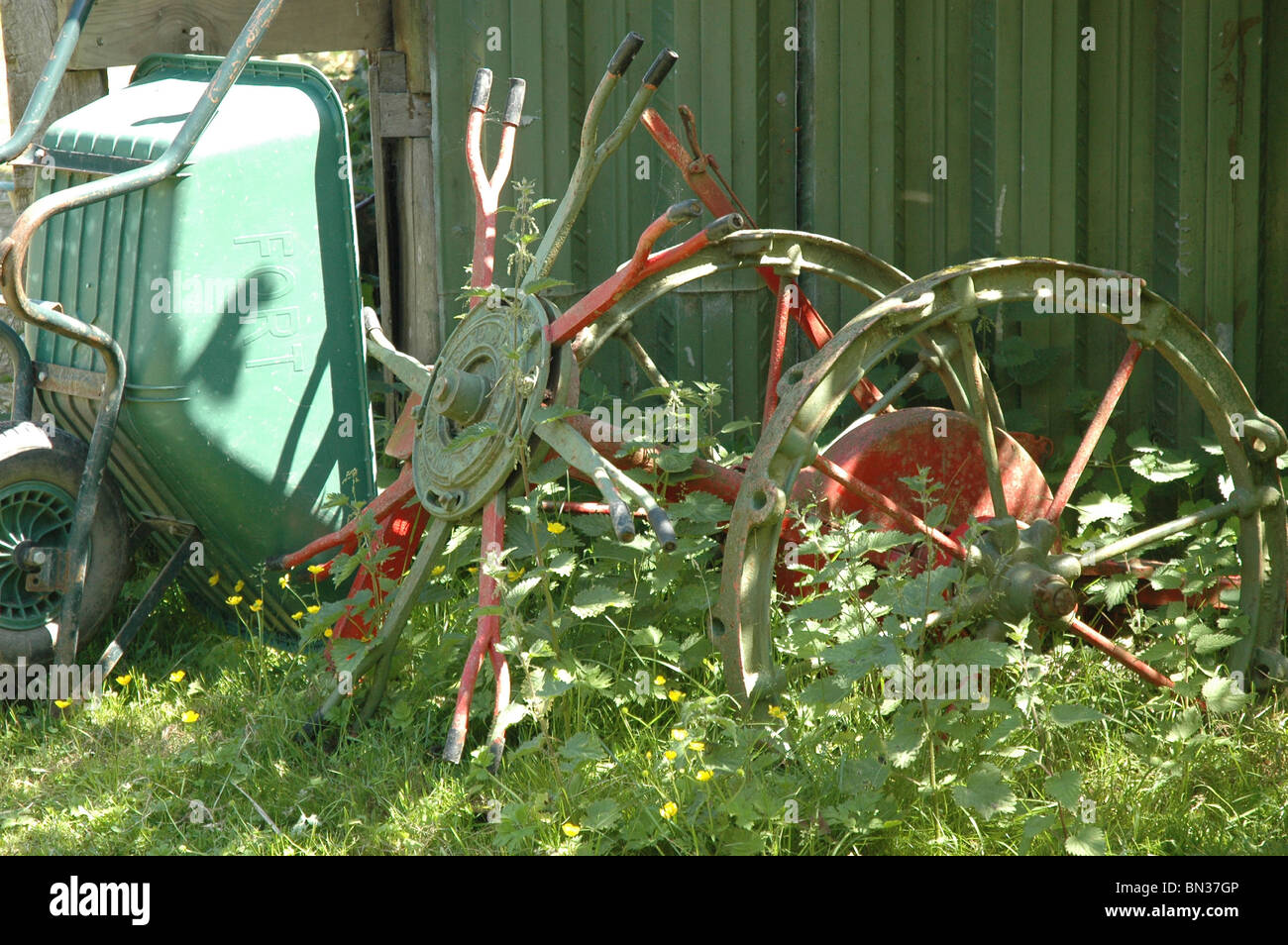 Old Potato picker in an overgrown field leaning against a green metal ...