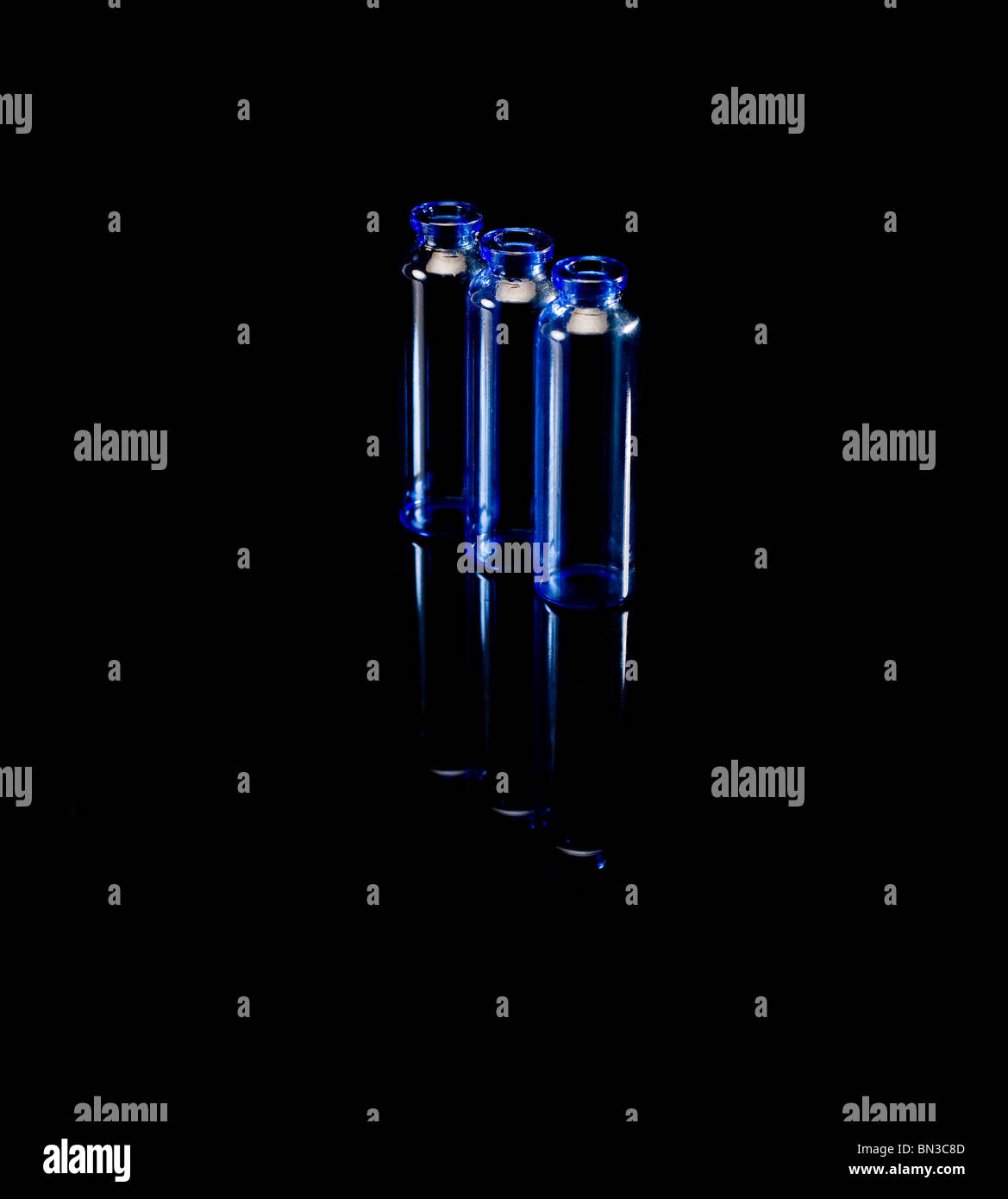 blue glass vials over black background backlit Stock Photo - Alamy