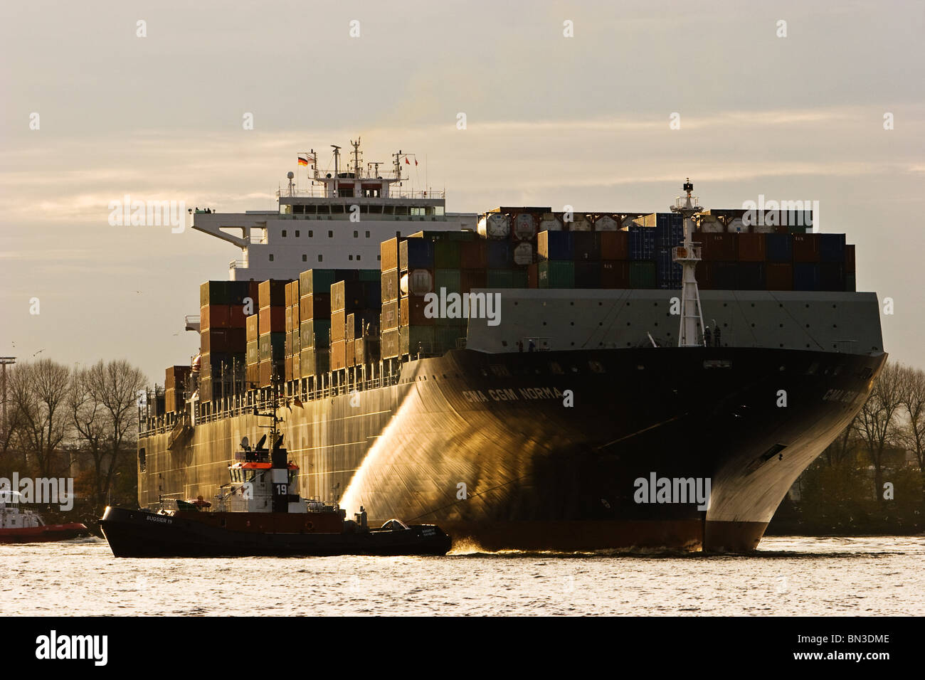 Tugboat pulling cargo ship, Hamburg harbour, Germany Stock Photo - Alamy