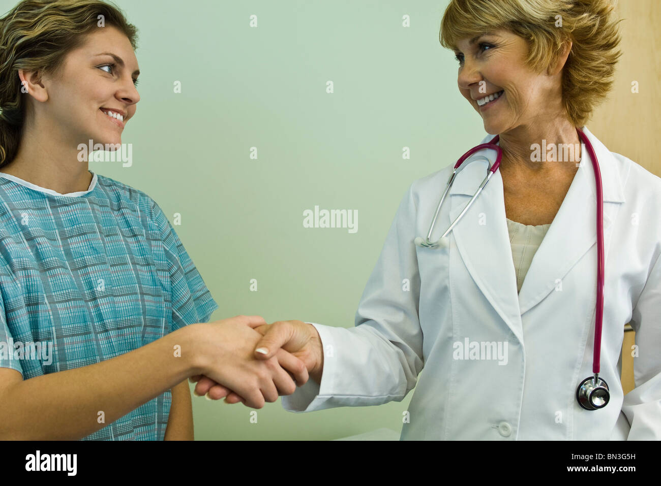 Doctor shaking hands with patient, both smiling Stock Photo - Alamy