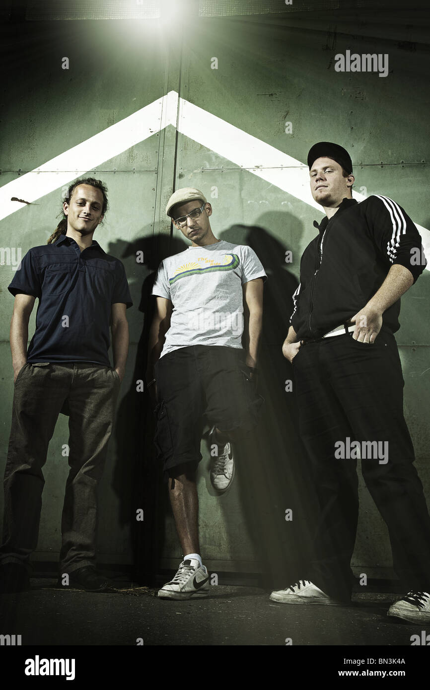 Three young men standing in front of a gate, portrait Stock Photo - Alamy