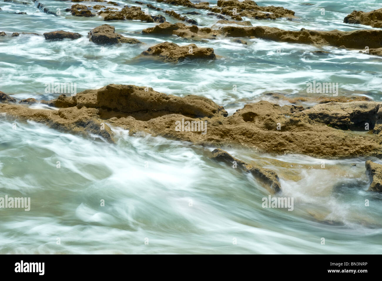 Water rushing over a reef along the beach Stock Photo - Alamy