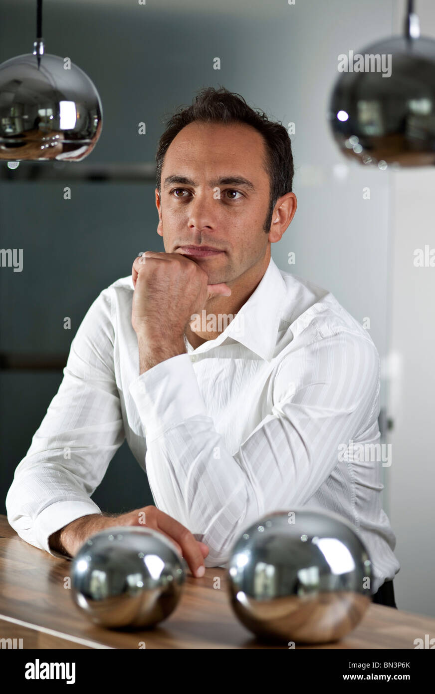Man leaning on counter Stock Photo - Alamy