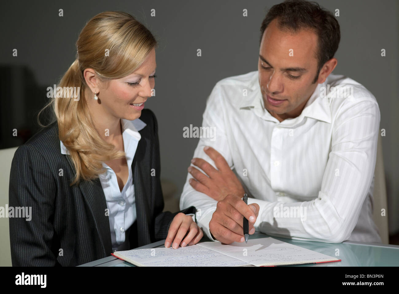 Business partner looking at notes Stock Photo - Alamy