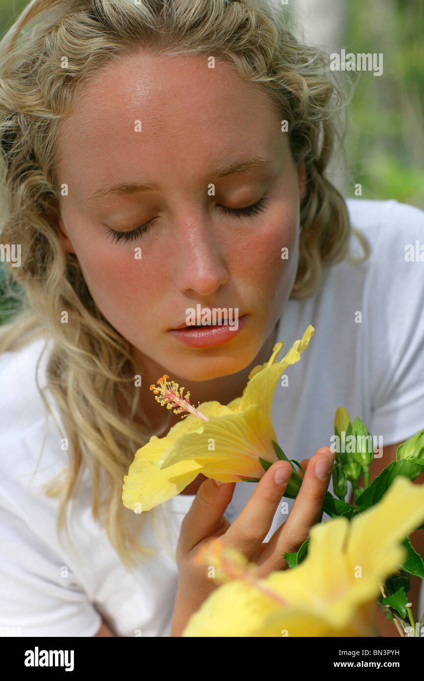 Young woman smelling a flower, portrait Stock Photo - Alamy