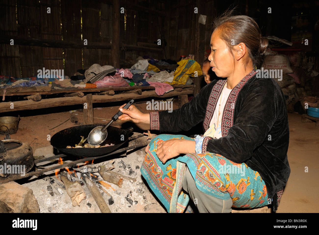 Woman cooking in a pot in her house in a Hmong village, Mae Hong Son ...