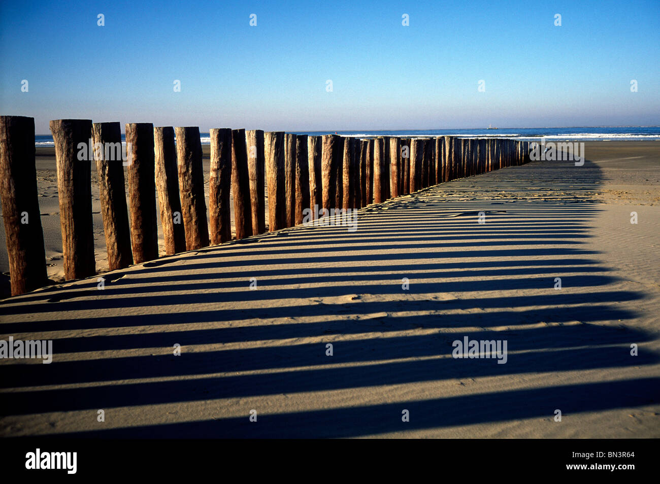 Shadow of wooden posts on beach Stock Photo - Alamy