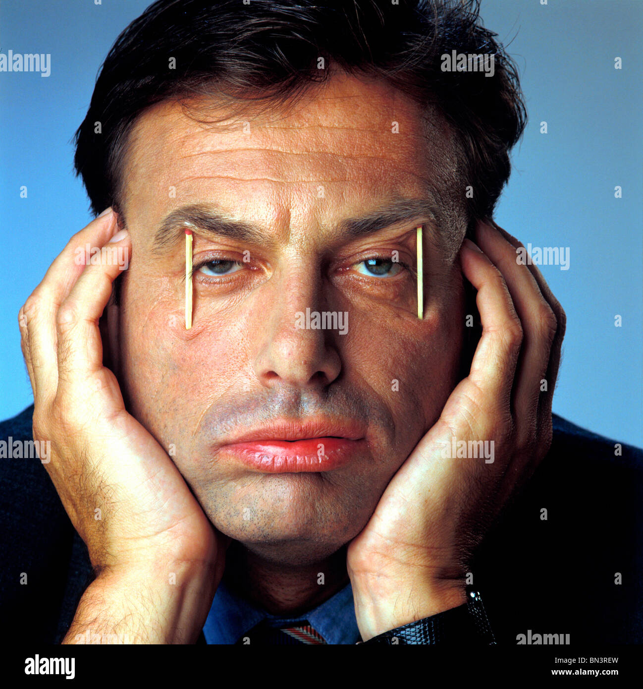 Portrait of man raising his eyebrows with matchsticks Stock Photo - Alamy