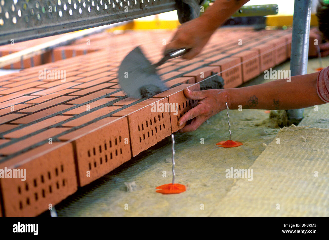 Mason making brick layer at building site Stock Photo - Alamy