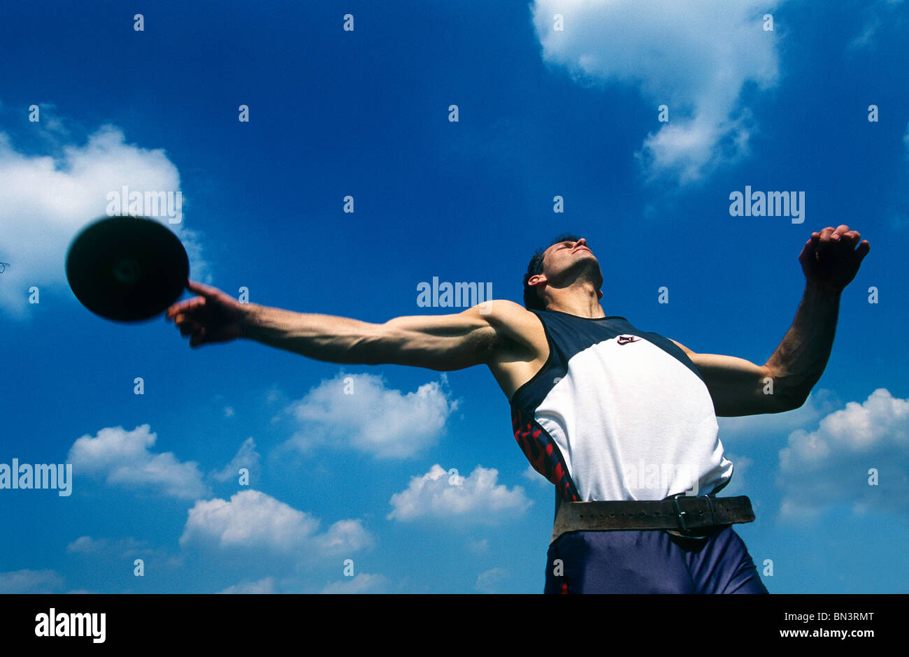 Low angle view of athlete throwing discus Stock Photo - Alamy