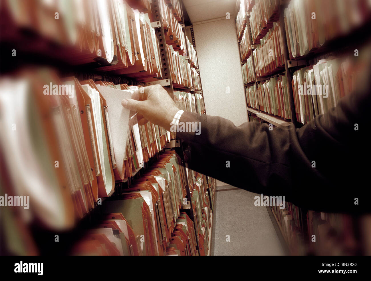 Man taking folder from rack Stock Photo - Alamy