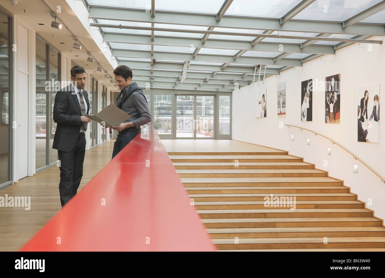two men standing in office building Stock Photo - Alamy