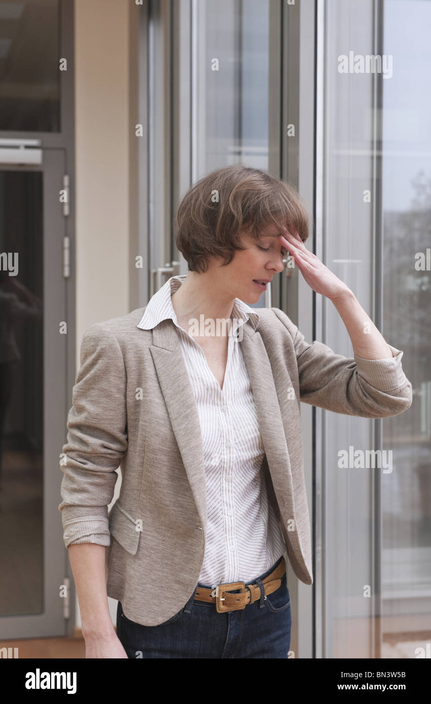 Woman touching forehead hand standing hi-res stock photography and ...