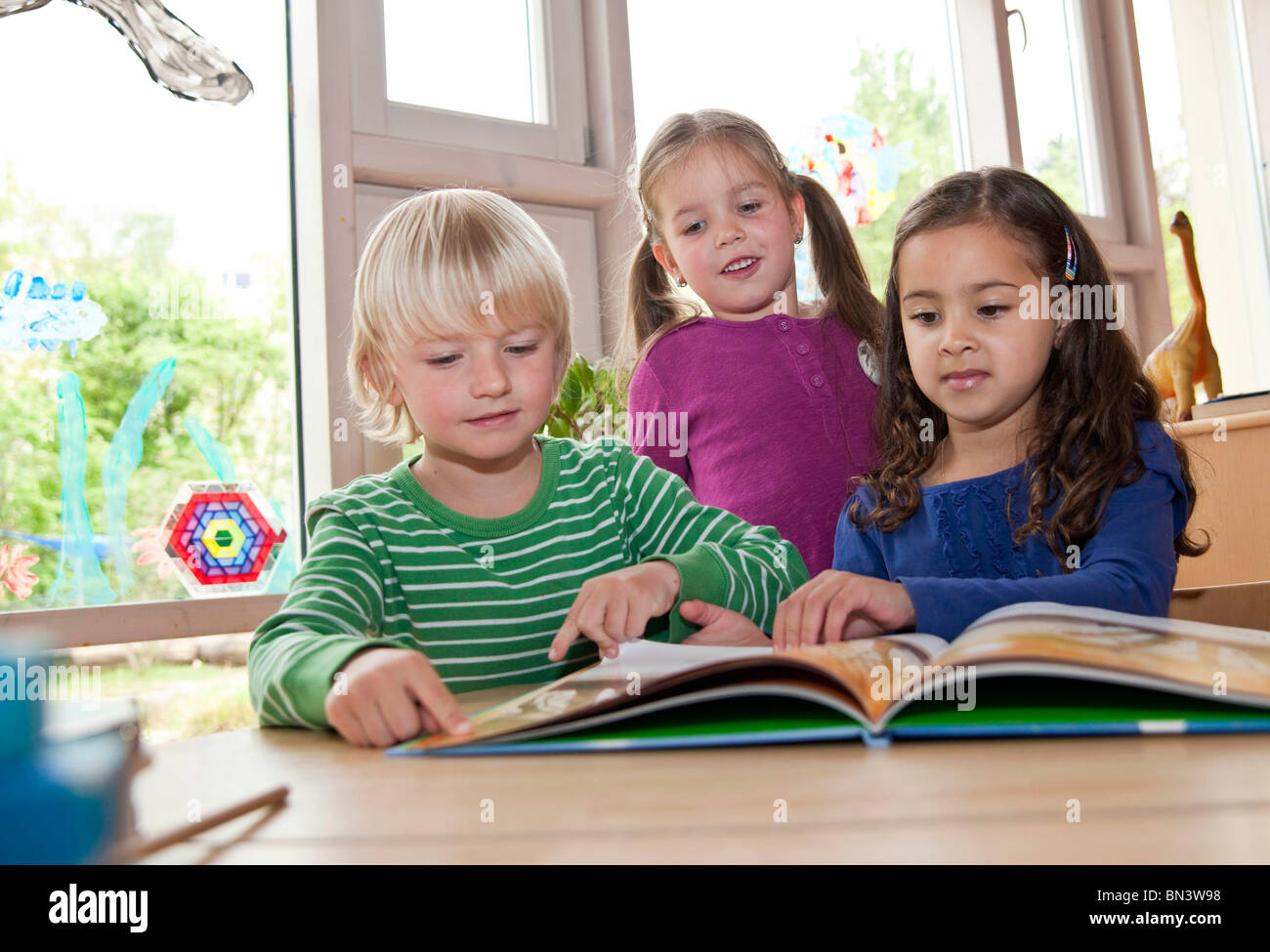Children looking at picture book, low angle view Stock Photo - Alamy