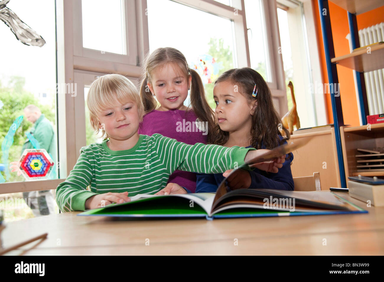 Children looking at picture book, low angle view Stock Photo - Alamy