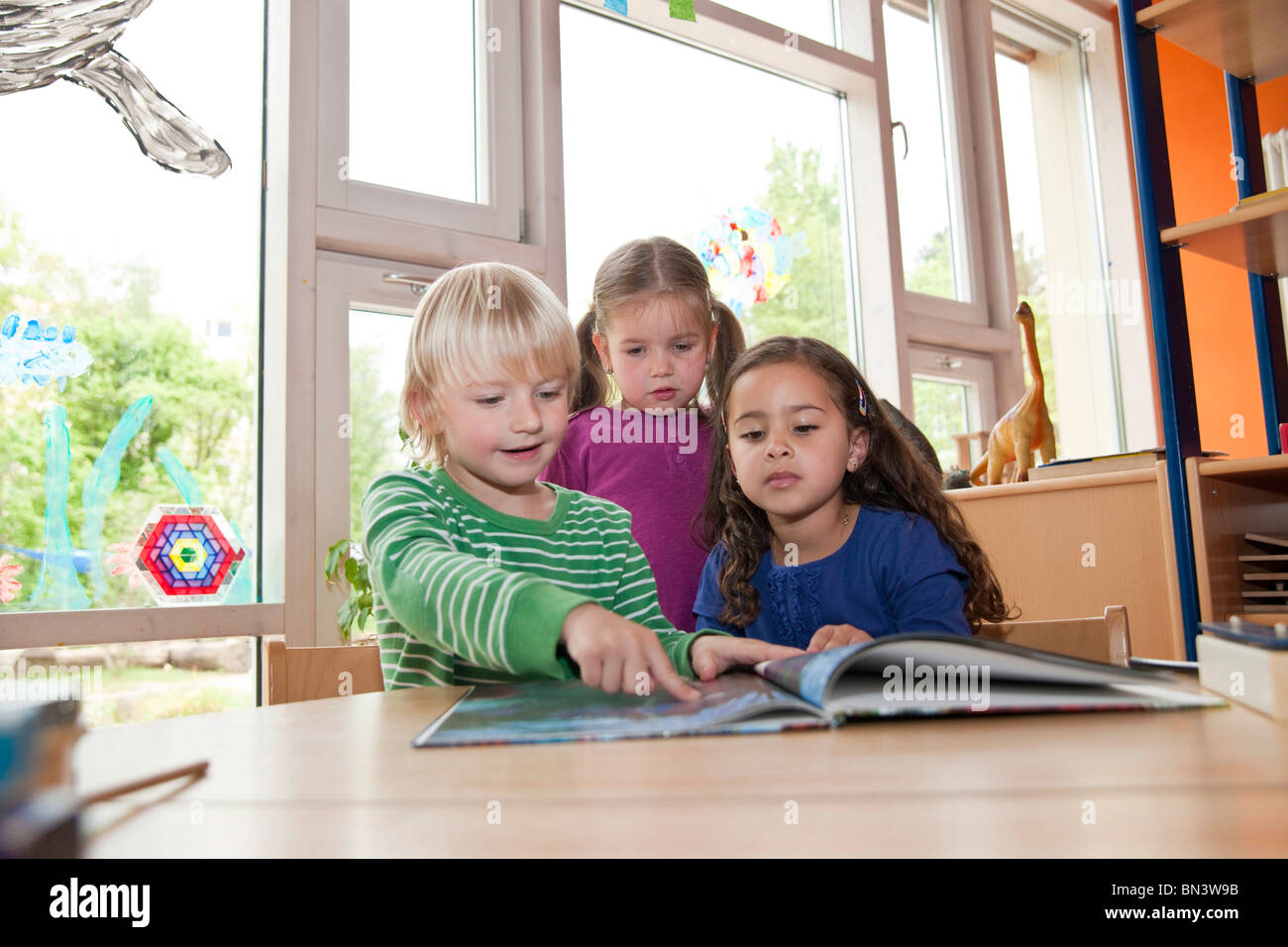 Children looking at picture book, low angle view Stock Photo - Alamy