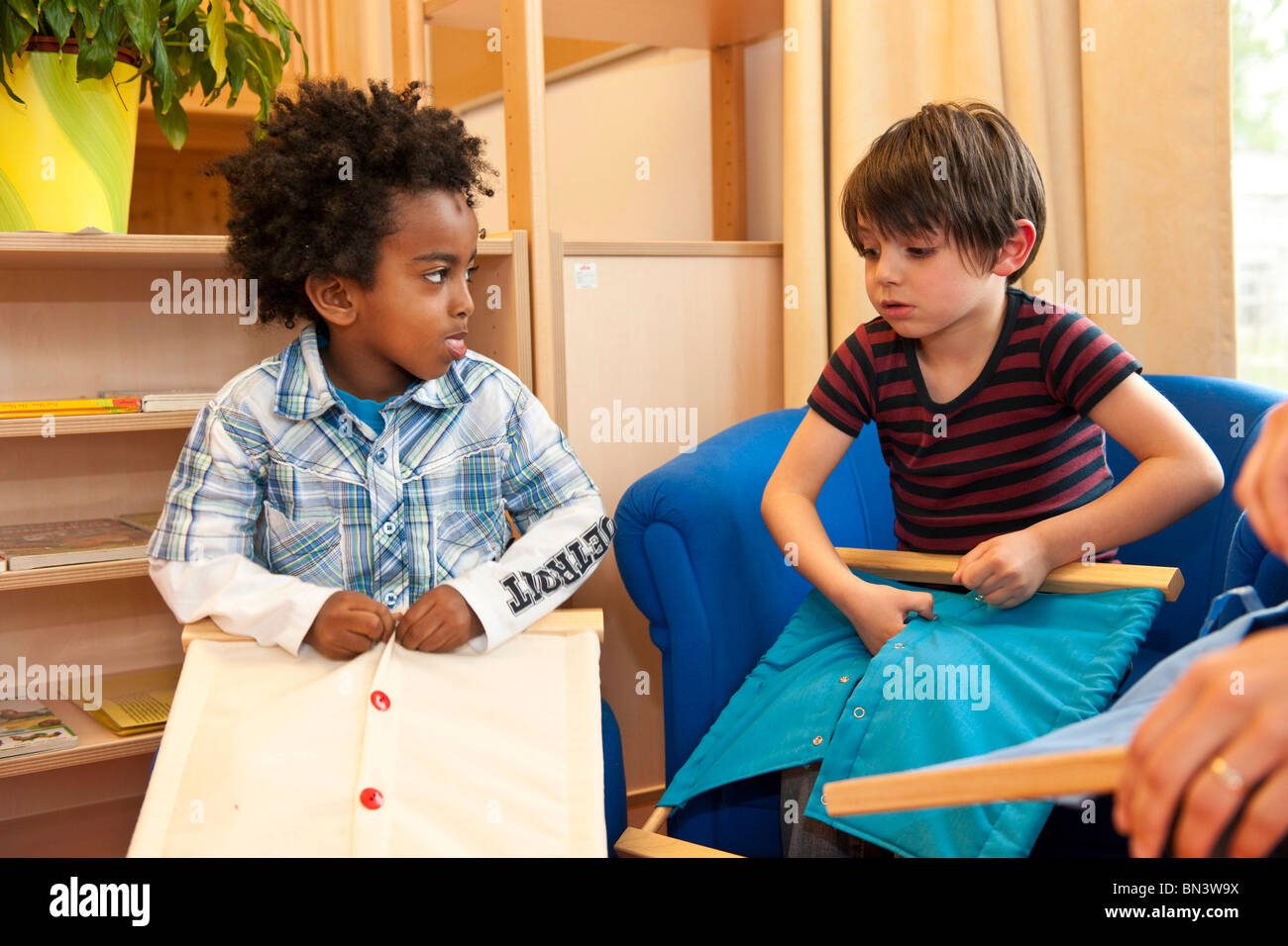 Little boys buttoning Stock Photo - Alamy