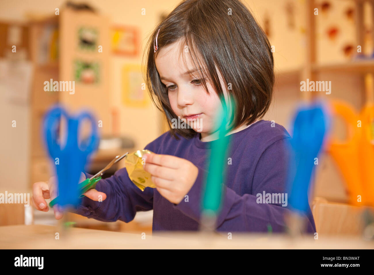 Little girl using scissors to cut paper, low angle view Stock Photo - Alamy