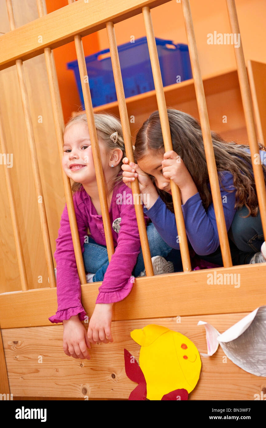 Young girls sitting behing a railing Stock Photo - Alamy