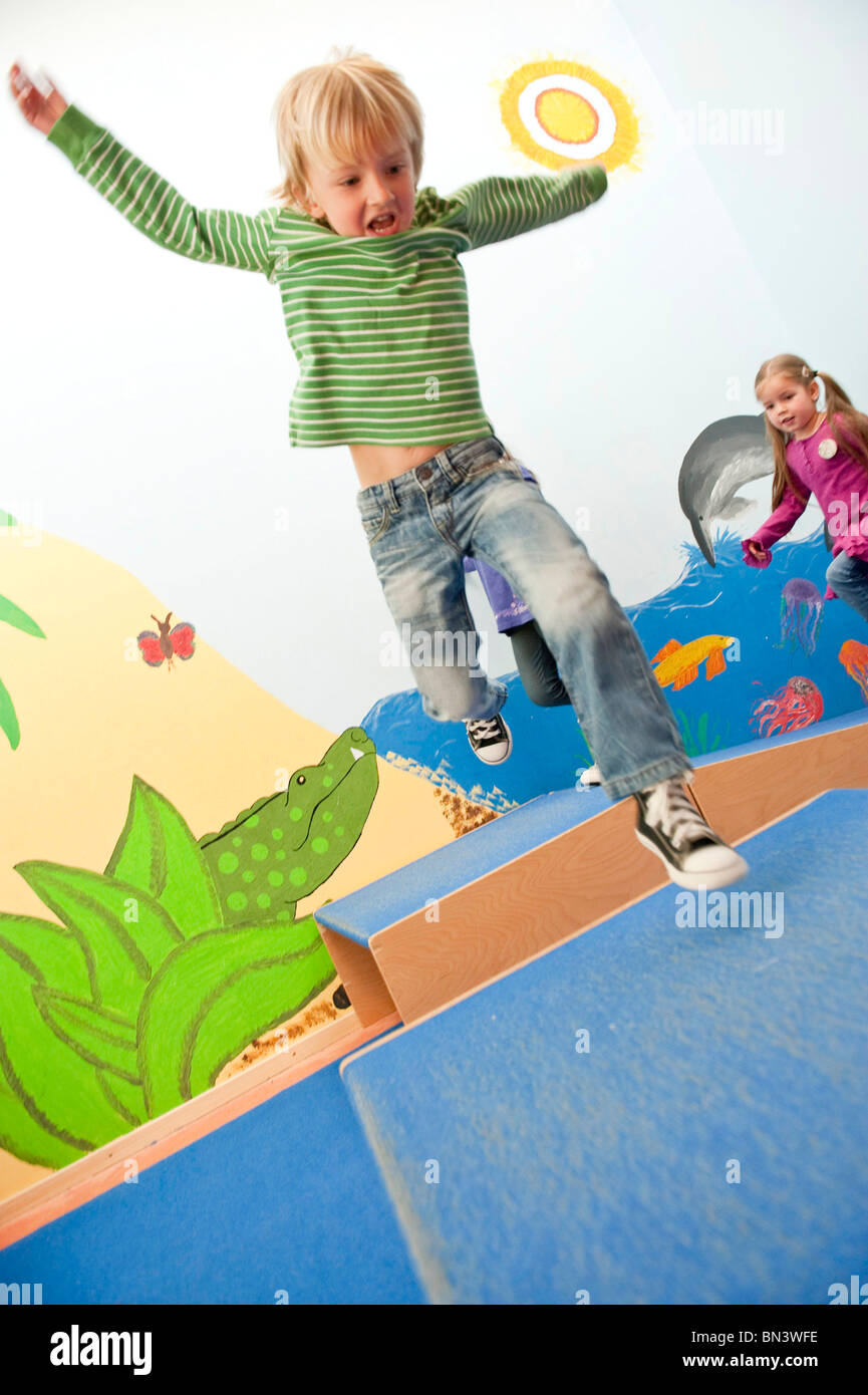 Children jumping over boxes, low angle view Stock Photo - Alamy