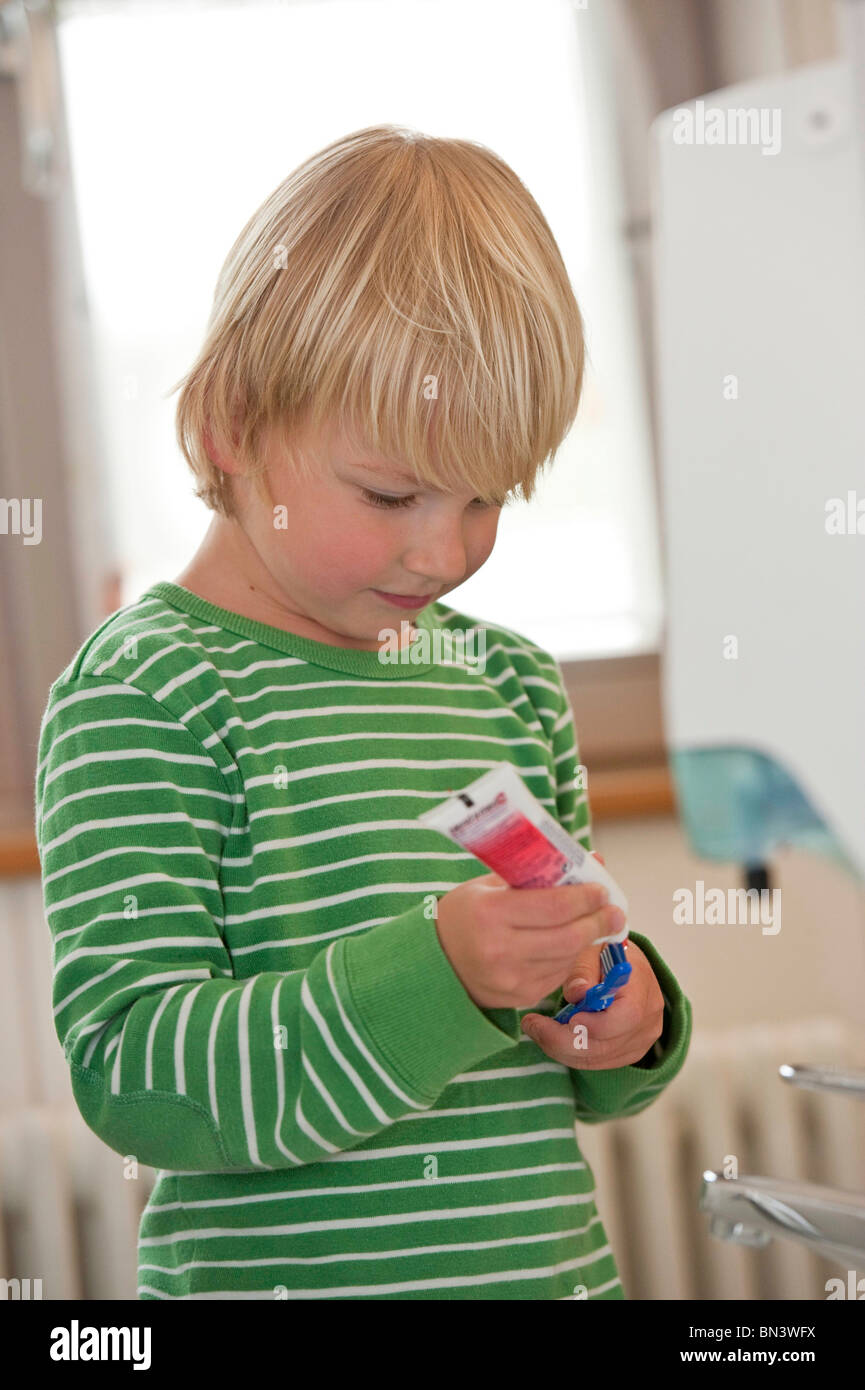 Young boy putting toothpaste on a toothbrush Stock Photo - Alamy