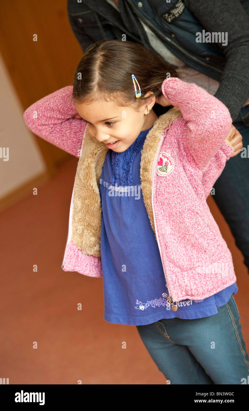 Child helping put on jacket hi-res stock photography and images - Alamy