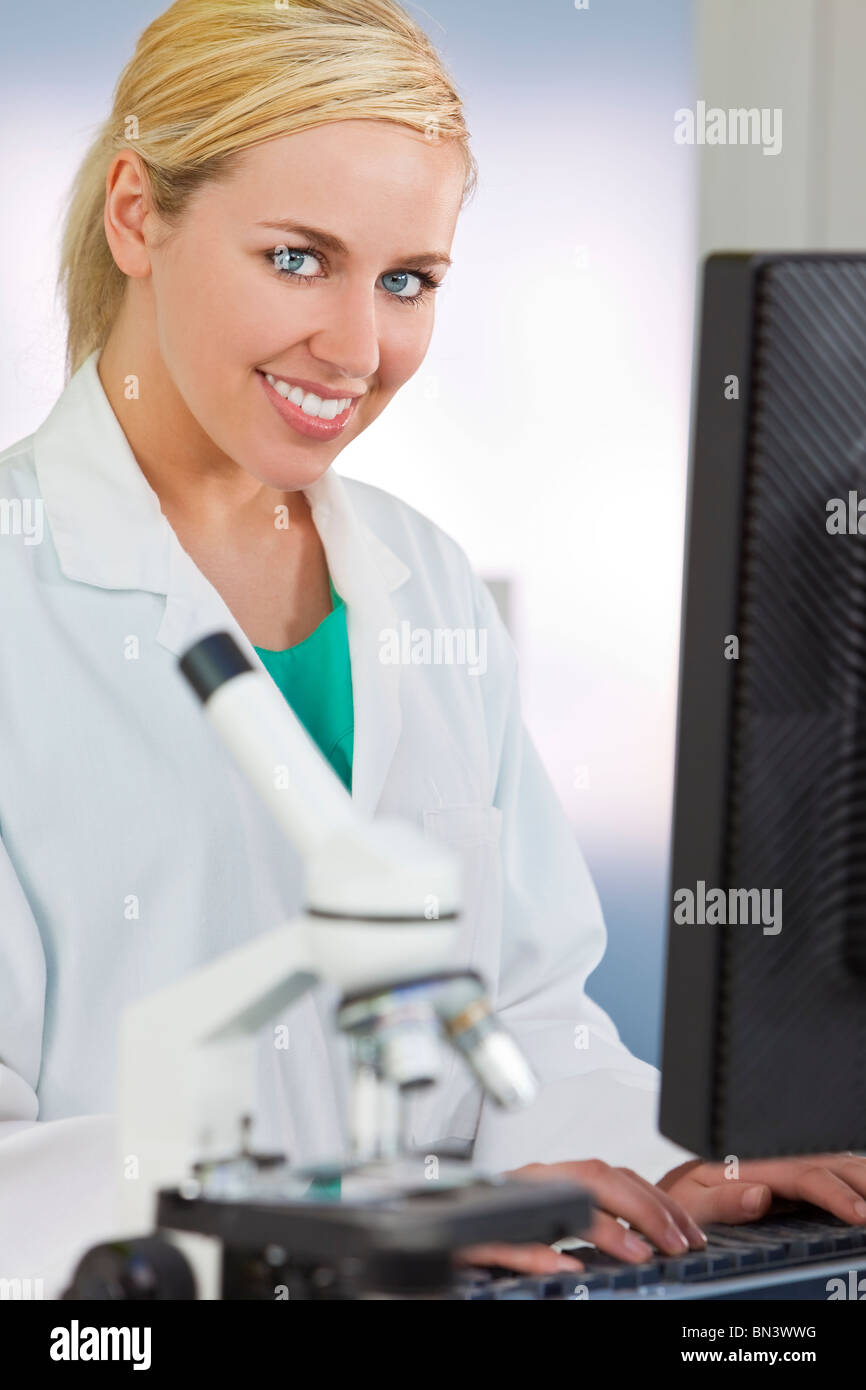 A smiling female medical or scientific researcher or woman doctor using ...