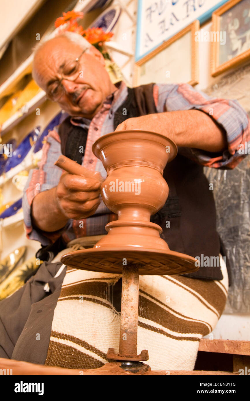 A pot spins on the wheel as Ben Mahmoud Habib concentrates in his work ...