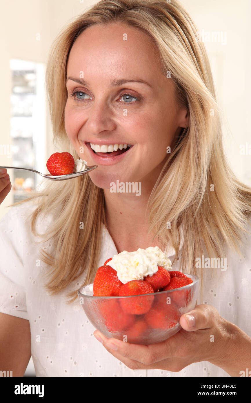 WOMAN EATING STRAWBERRIES AND CREAM Stock Photo - Alamy