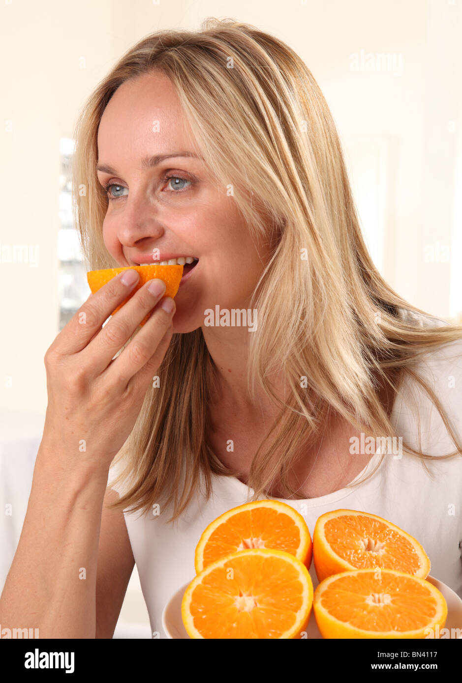 WOMAN EATING ORANGES Stock Photo - Alamy