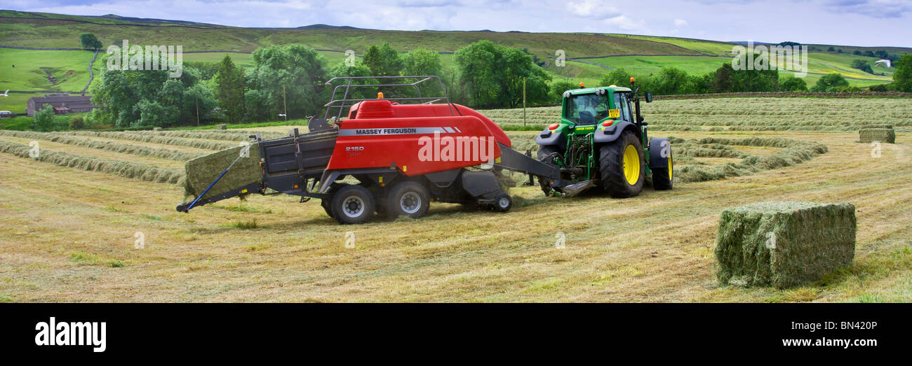 Working tractor in field making bales from cut grass / hay Stock Photo ...
