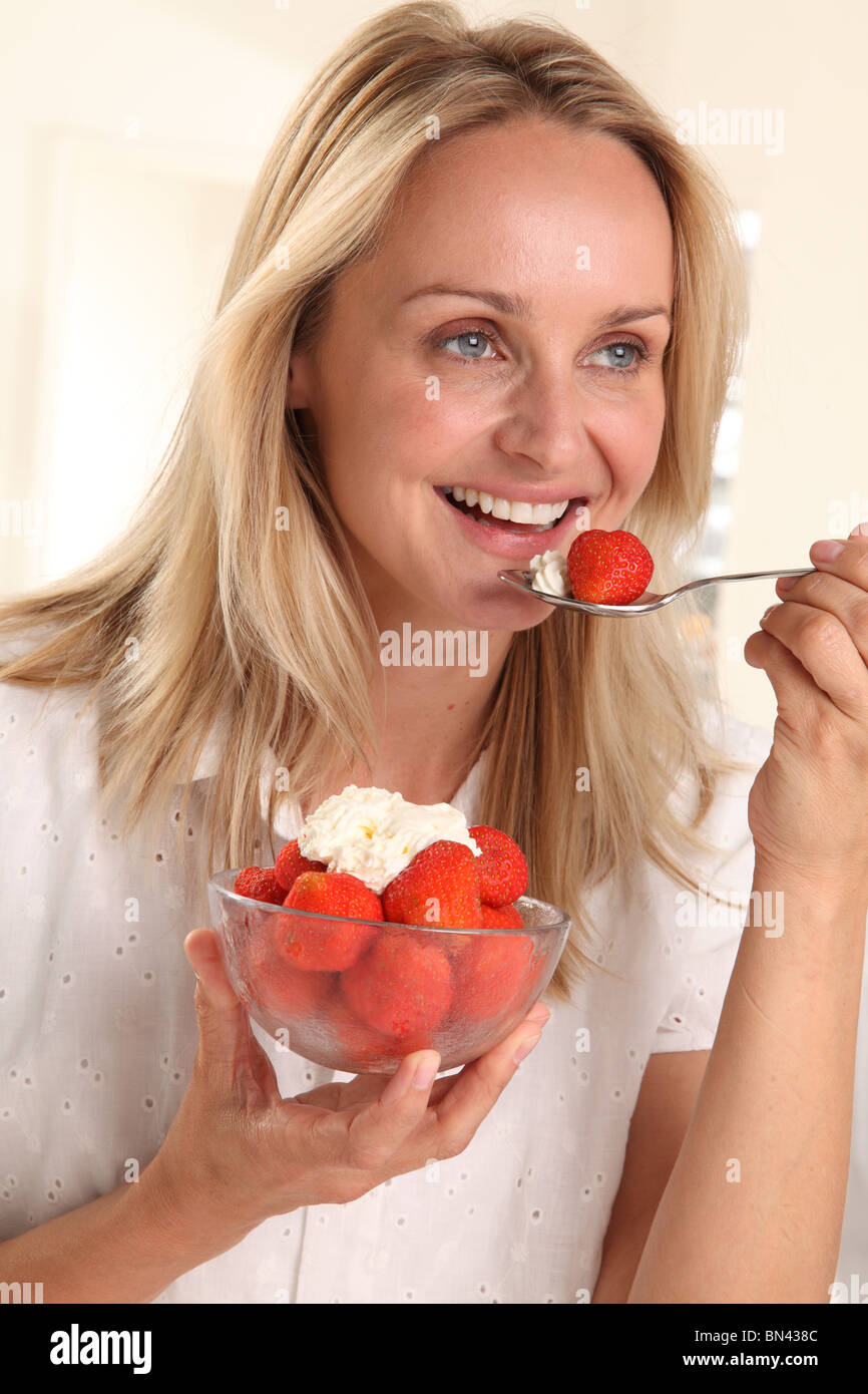 WOMAN EATING STRAWBERRIES AND CREAM Stock Photo - Alamy