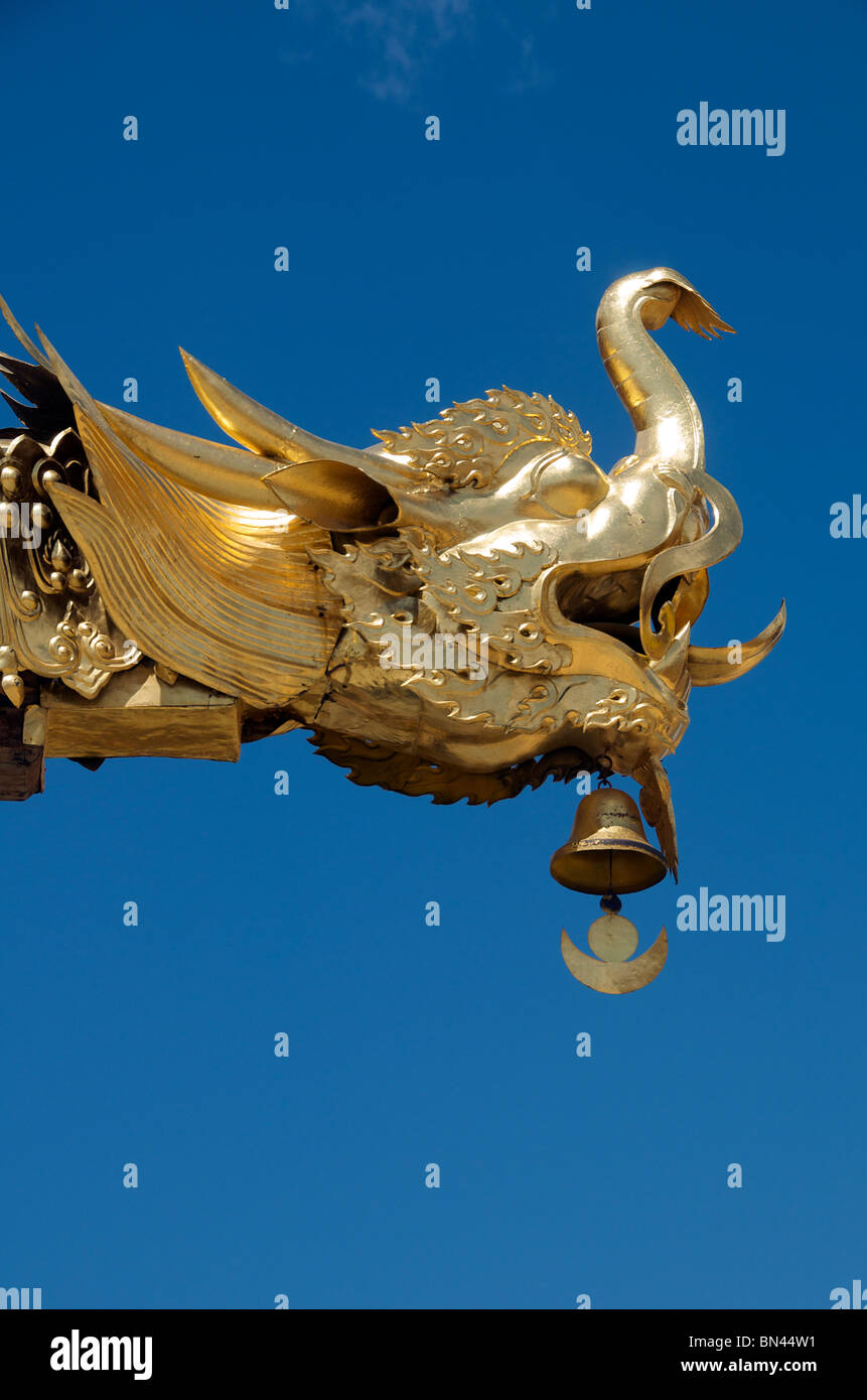 Ornate gilt dragon head on roof of Ganden Sumtseling Gompa or ...