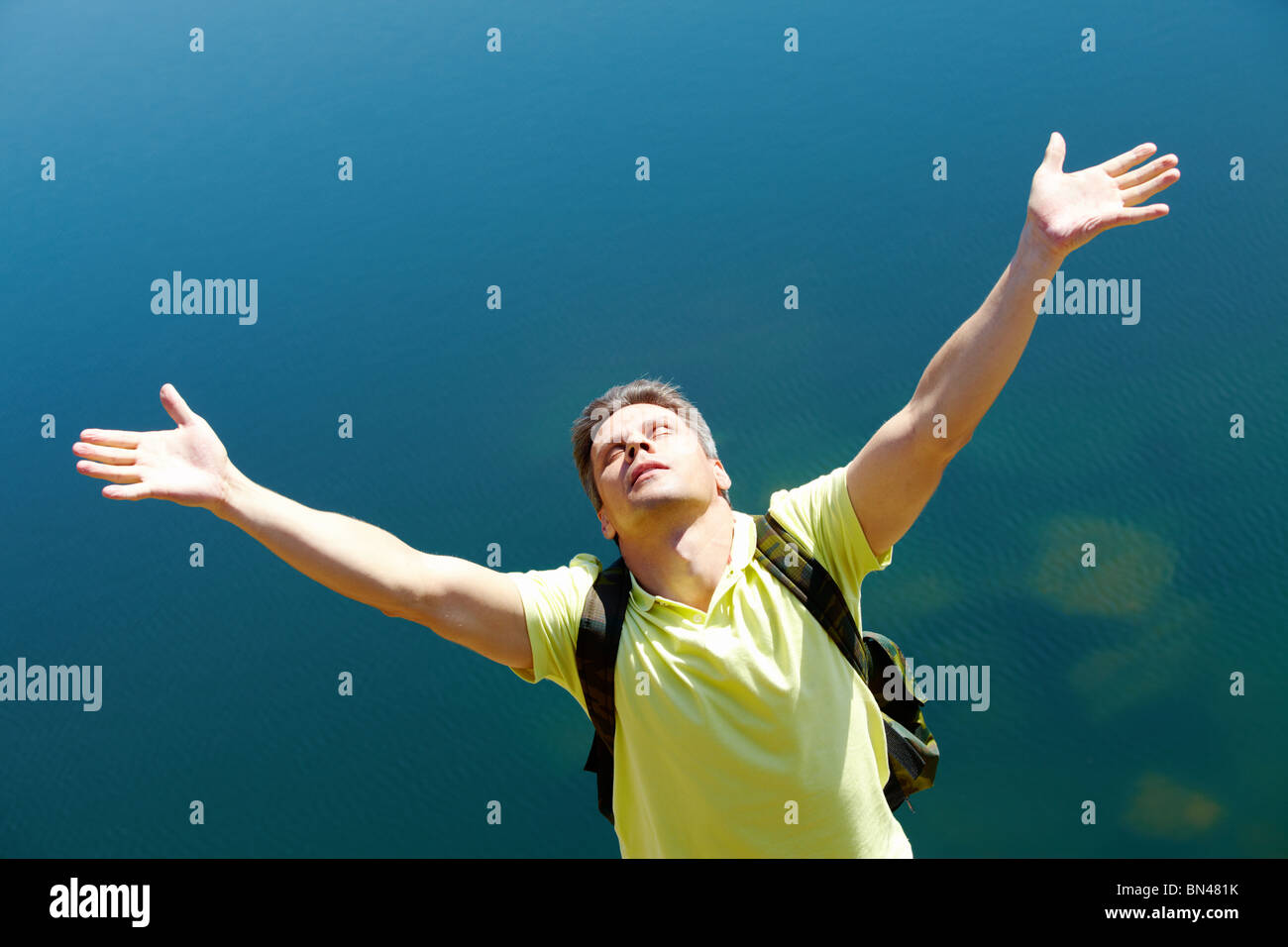 Image of man with stretched arms on background of water outdoors Stock ...