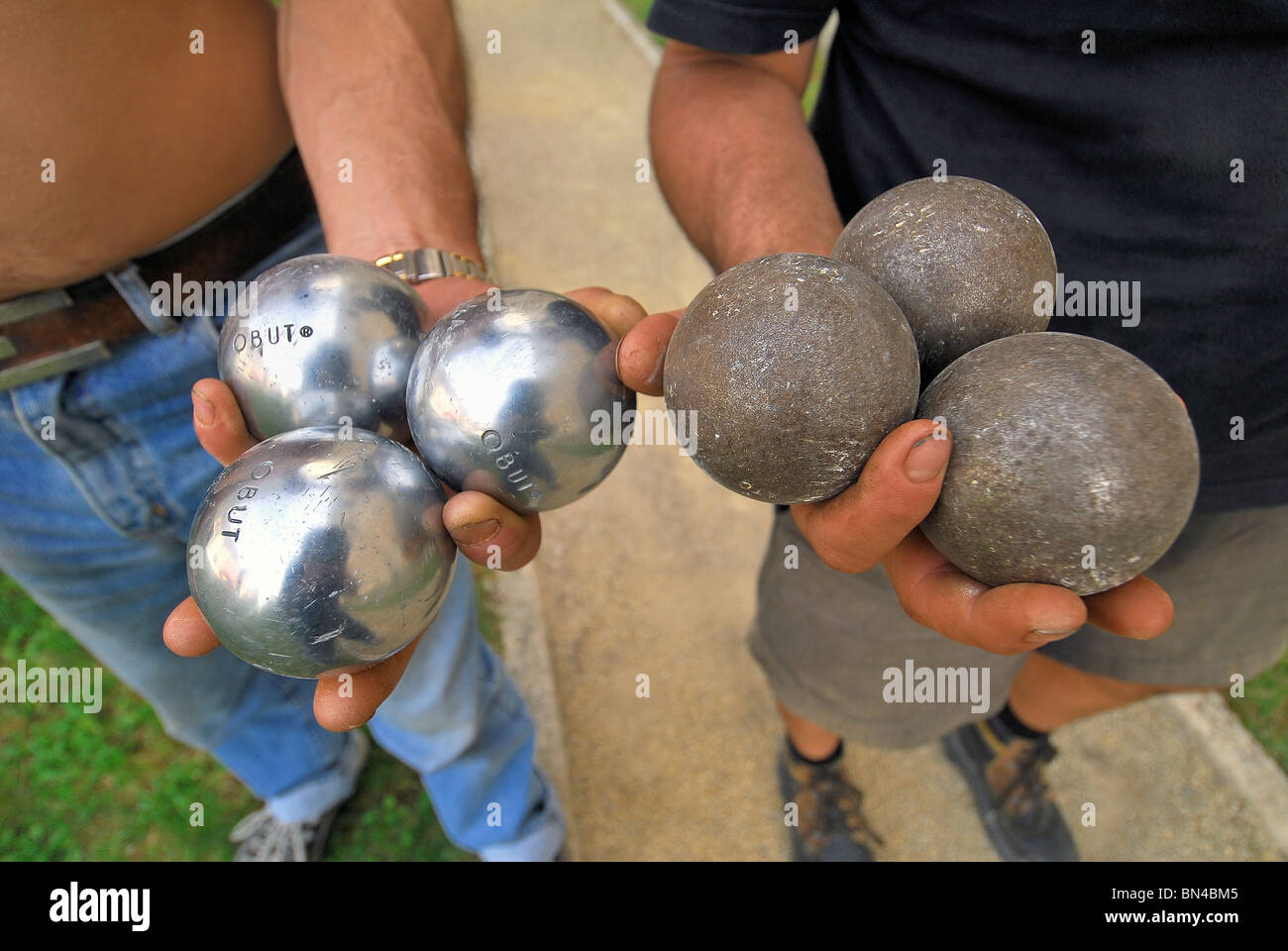 Two men holding six boules in hands - France Stock Photo - Alamy