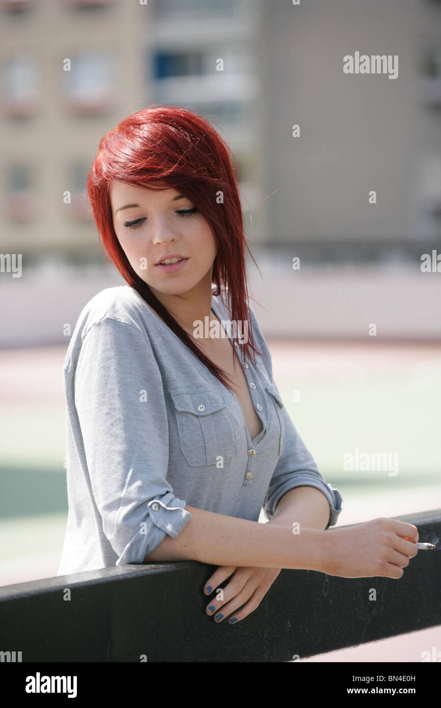 Red haired teenage girl smoking outside Stock Photo - Alamy