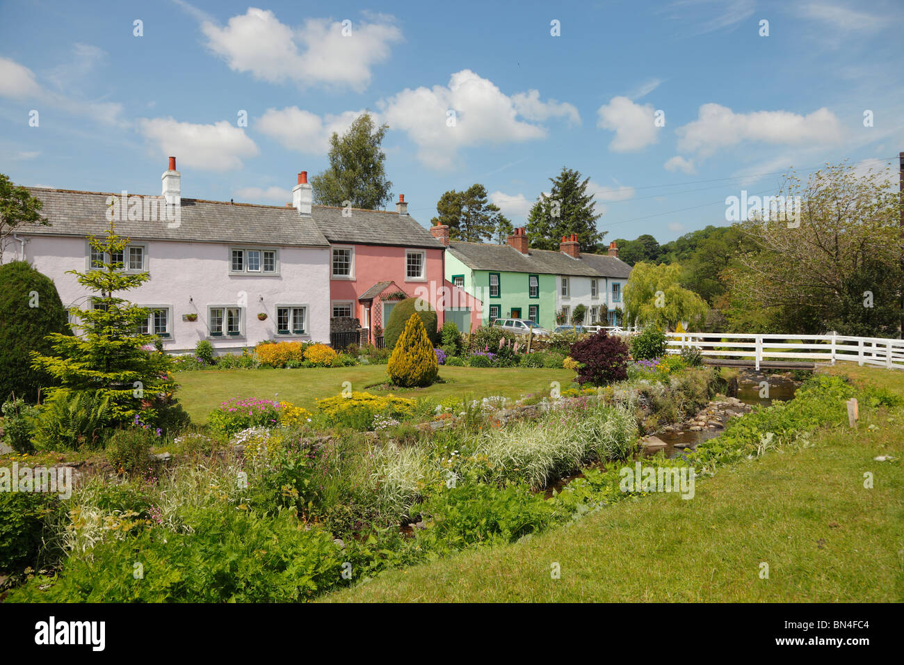 Colourful cottages with stream in front. In Calbeck, The Lake District ...