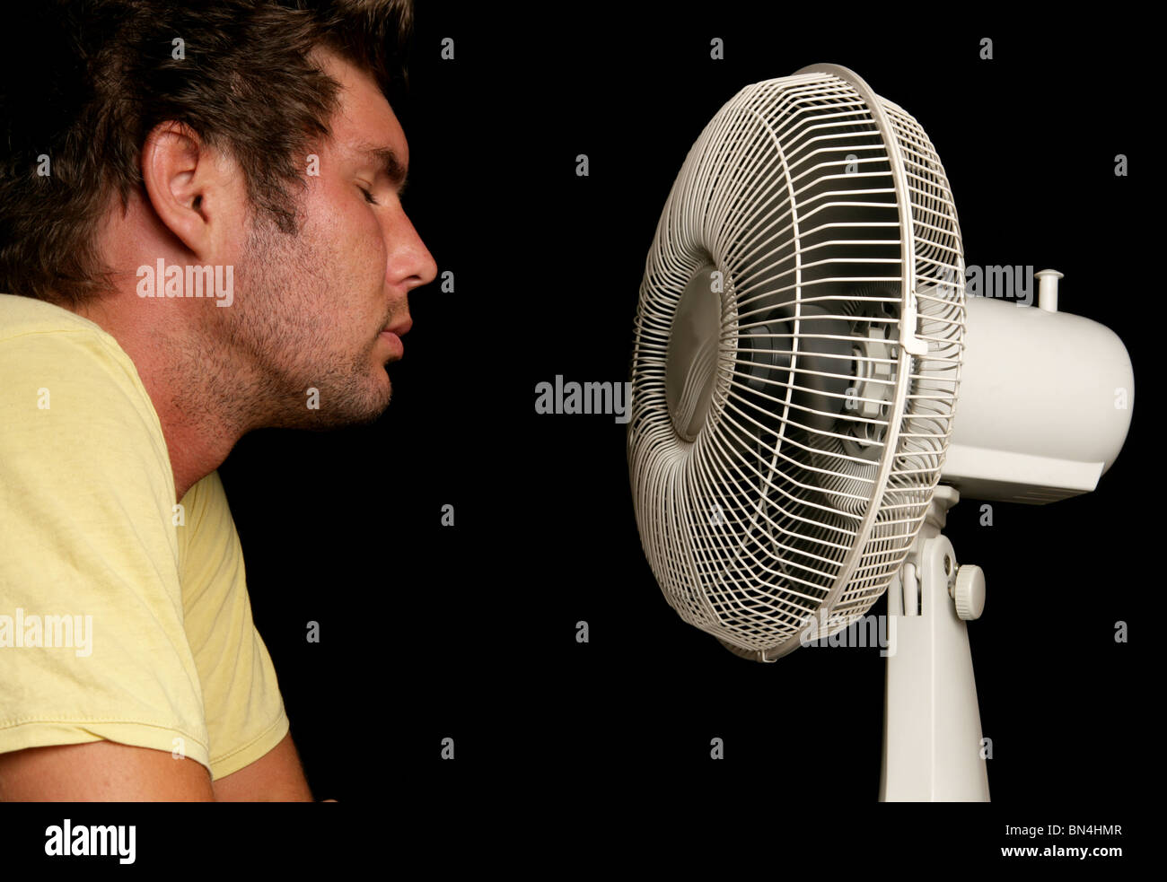 Man and Fan on black background Stock Photo - Alamy