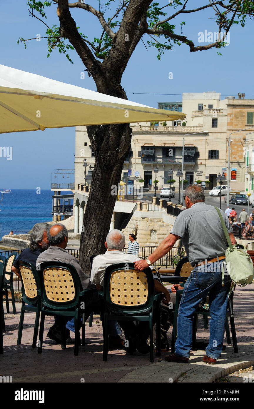 BALLUTA BAY, ST JULIAN'S, MALTA. A group of Maltese men sitting and ...